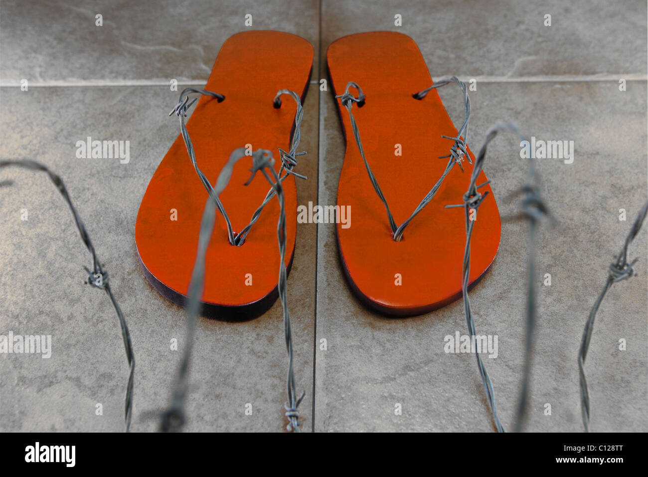 Orange barbed wire flip-flops behind barbed wire fence Stock Photo - Alamy