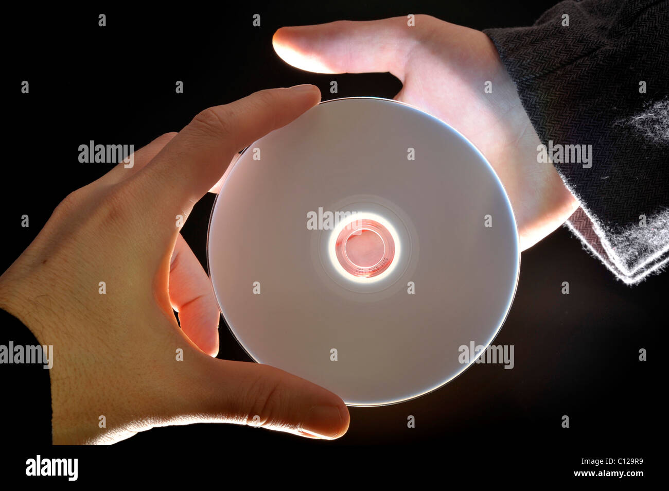 Hand passing a data cd Stock Photo - Alamy