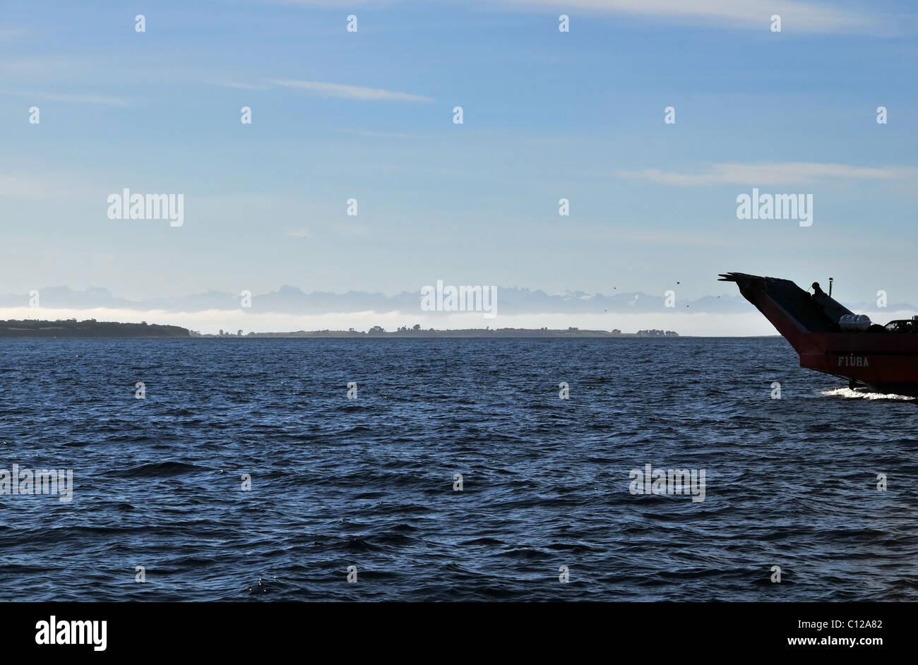 Blue waters of Chacao Channel, with ferry boat crossing from the right ...