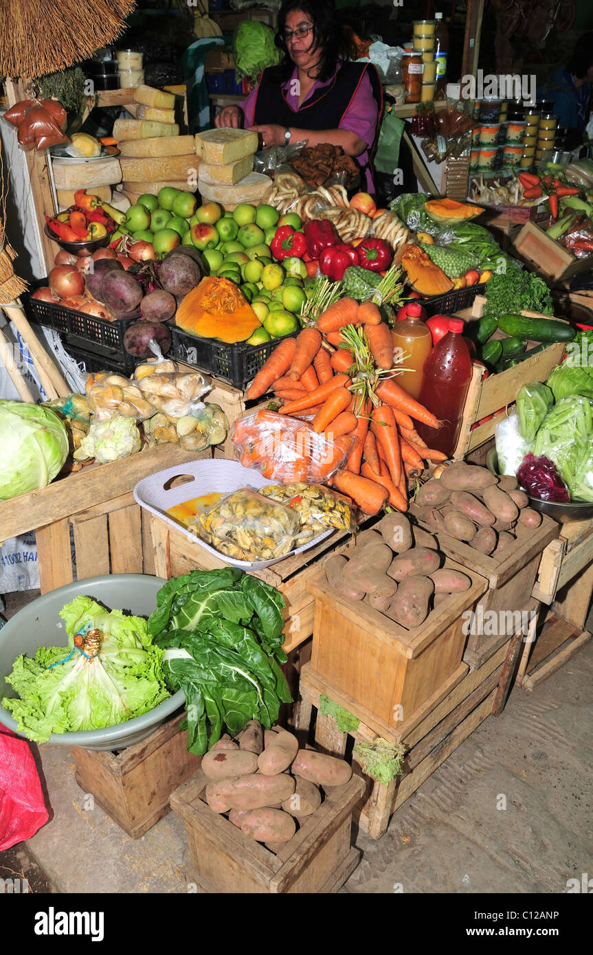 Lady shopkeeper tending vegetables and fruits on the wood boxes of an ...