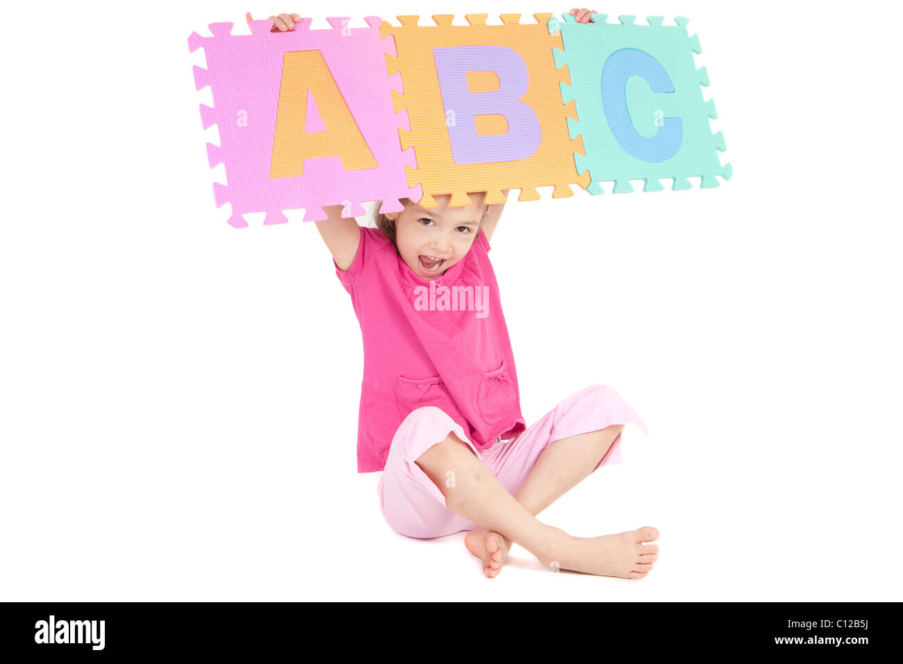 Girl holding alphabet abc sign above her head. Isolated on white Stock ...