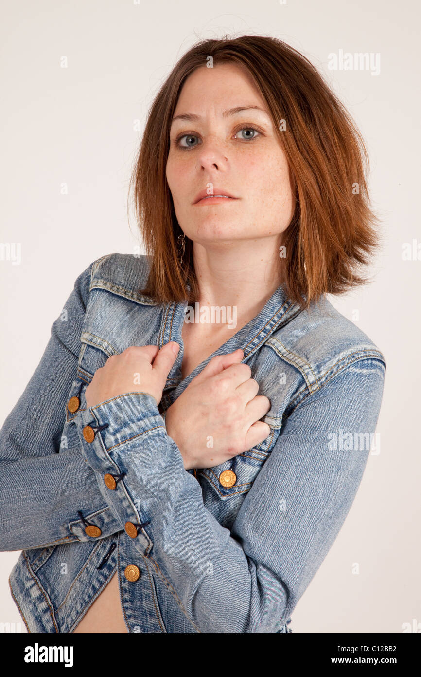 Lovely Redhead Woman In Jean Jacket With Her Arms Crossed Across Her