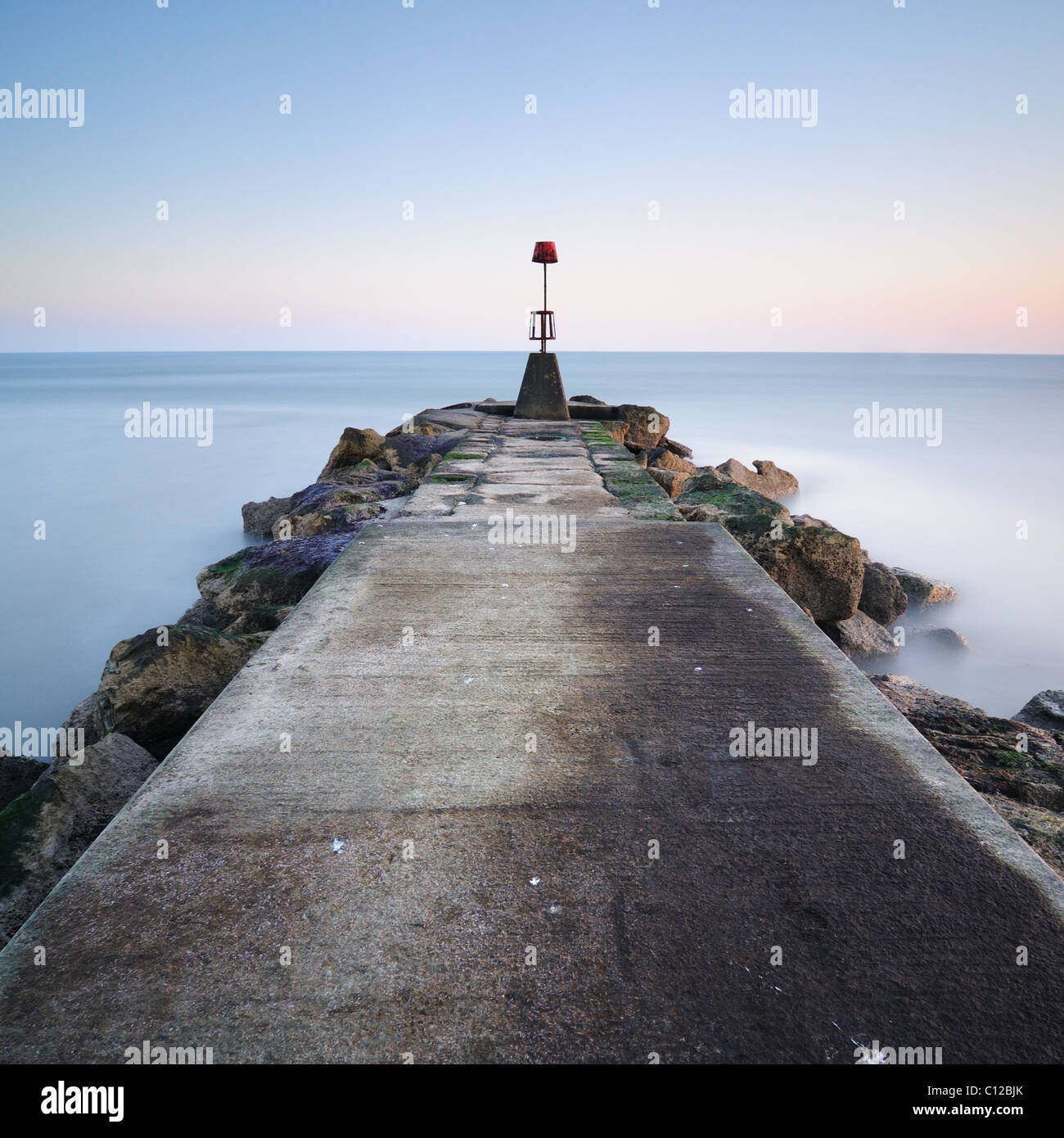 A groyne and marker at sunset Stock Photo - Alamy