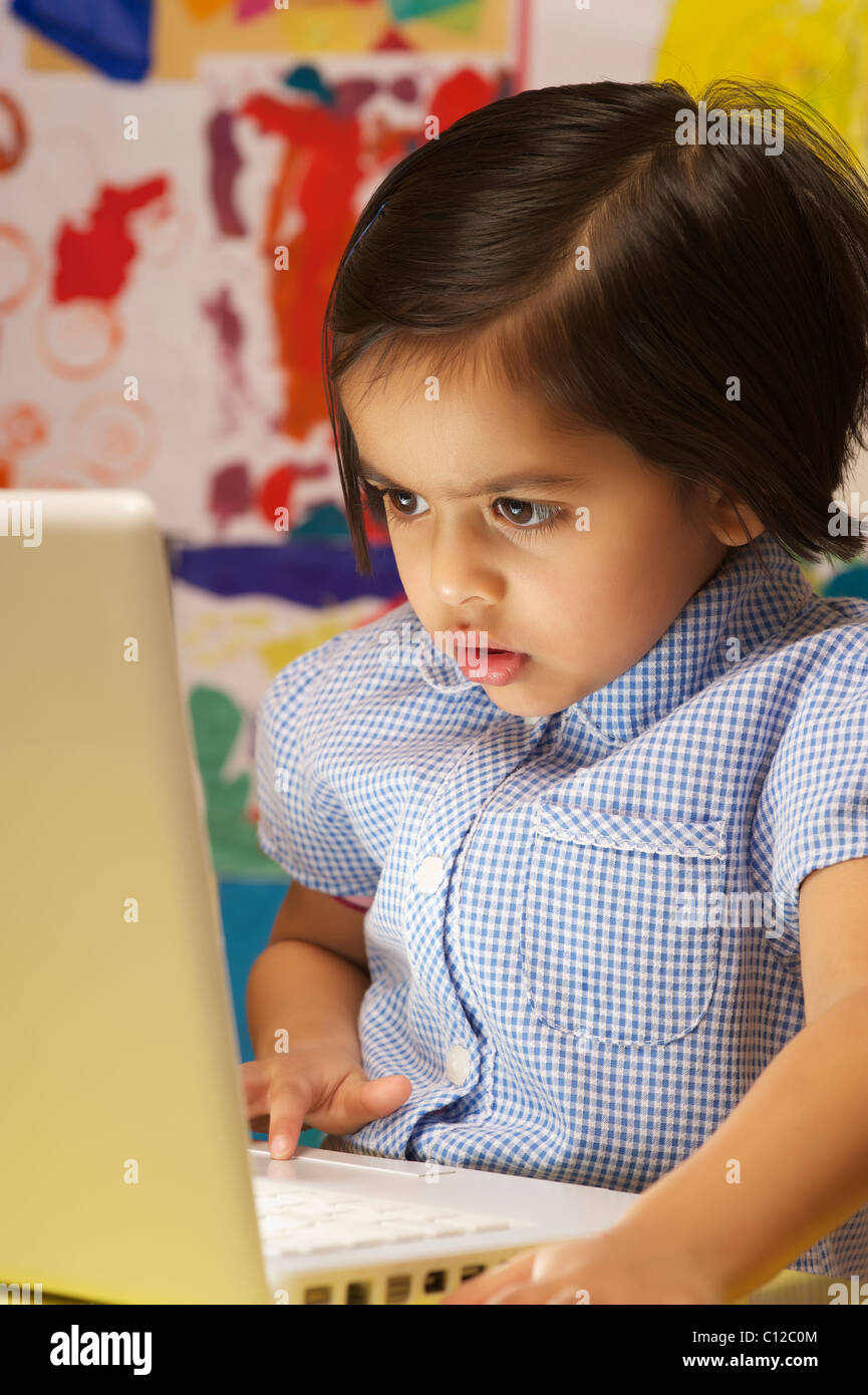 A young school girl looking at a laptop computer uk Stock Photo - Alamy