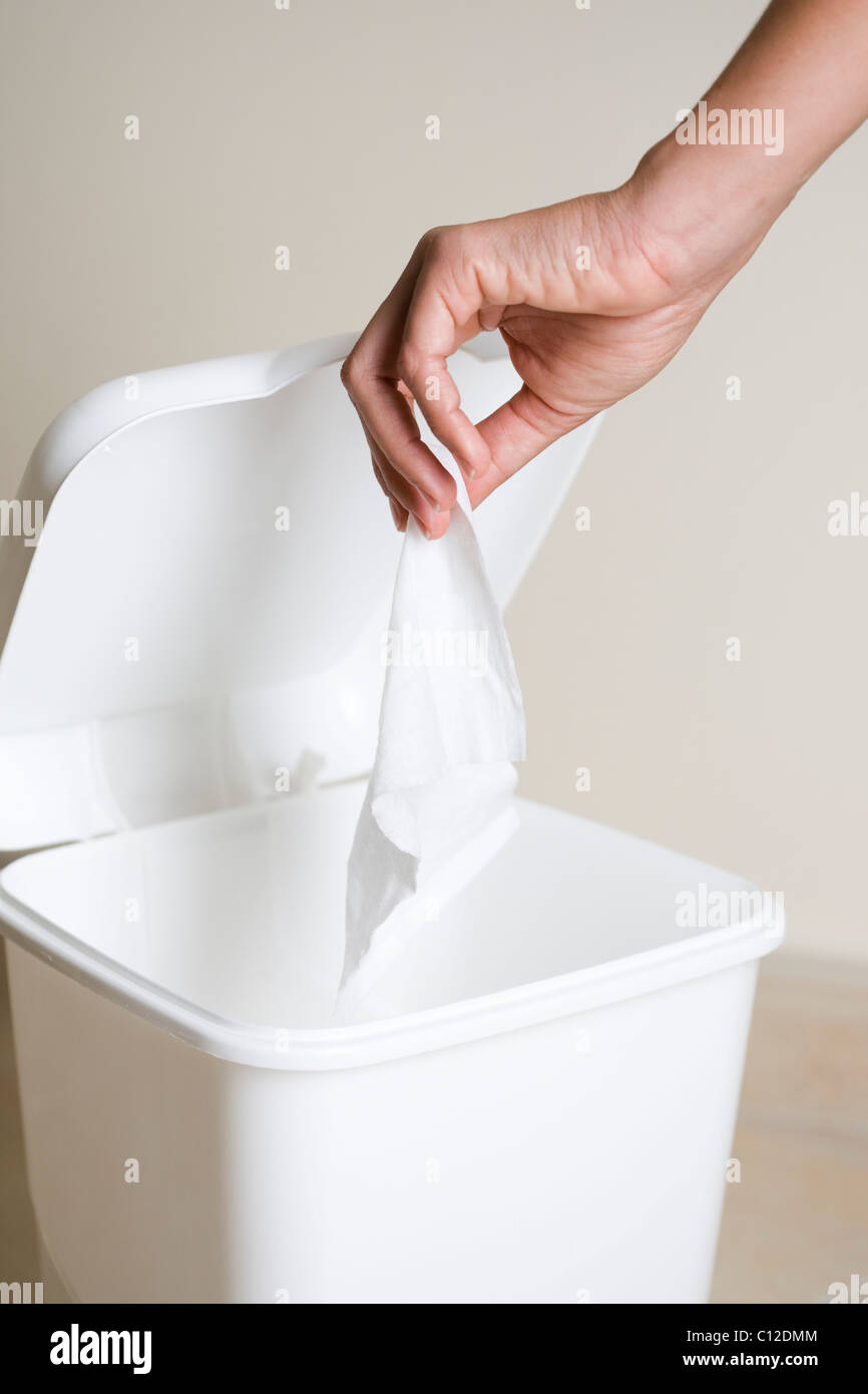 Young female hand throwing away a used issue as prevention Stock Photo ...