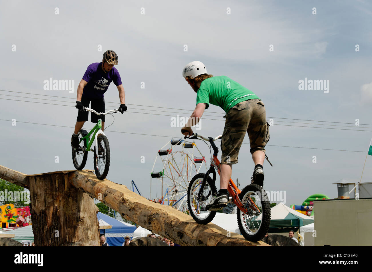 Two stunt bike riders balancing on a log Stock Photo - Alamy
