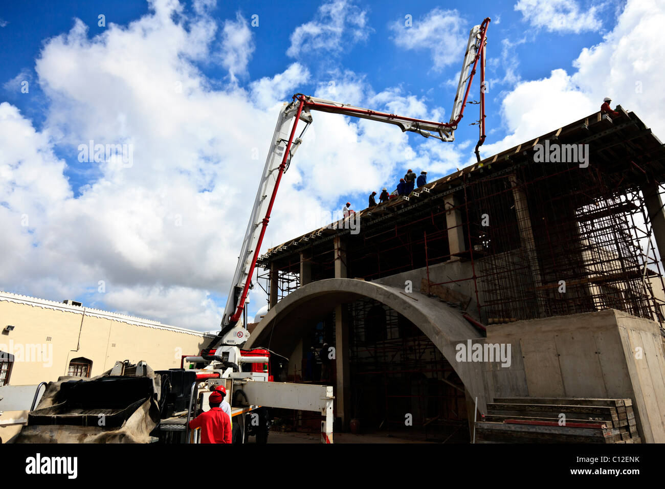 Concrete pumping on construction site using an articulated arm fed by a ...