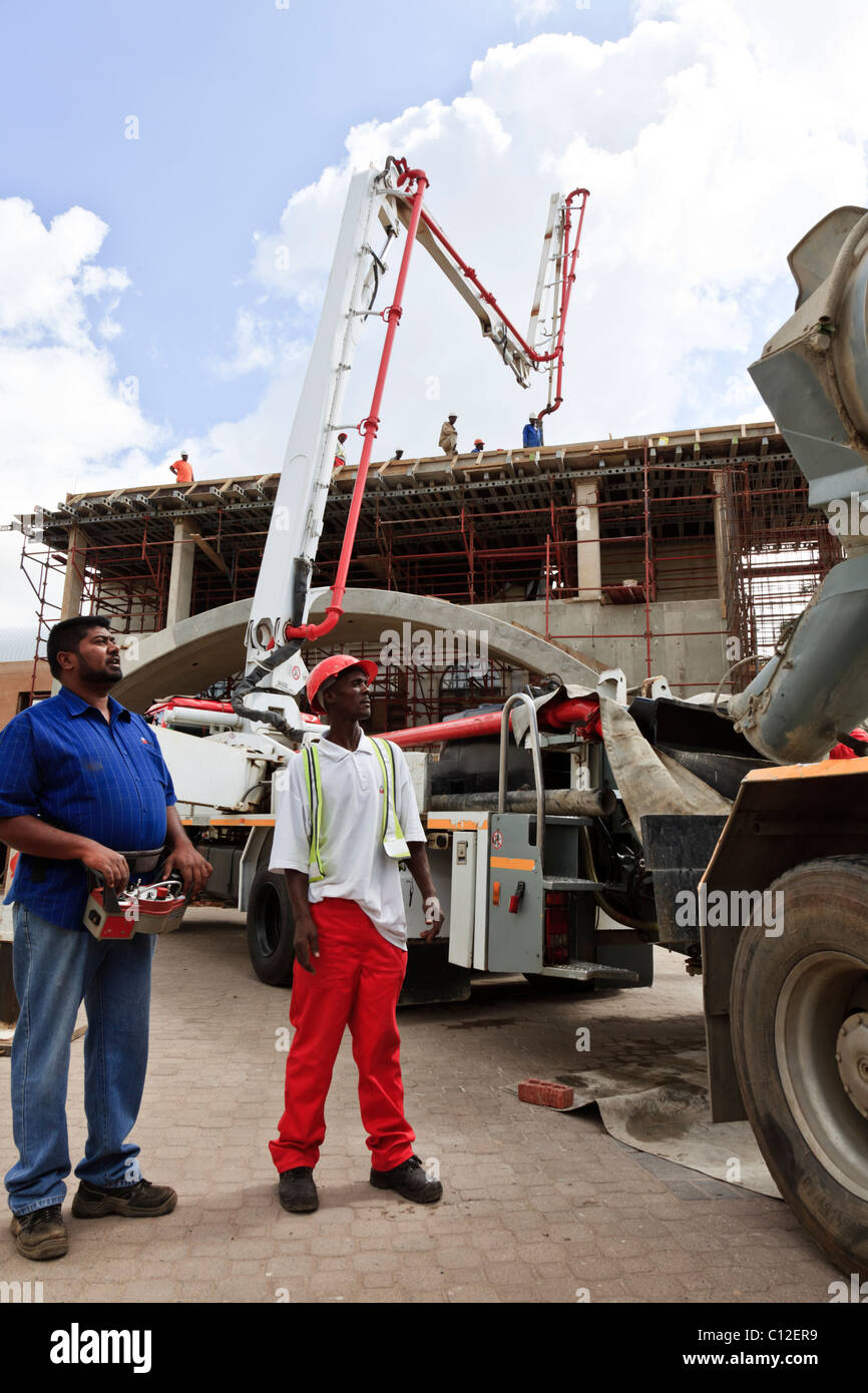 Concrete pumping on construction site using an articulated arm fed by a ...