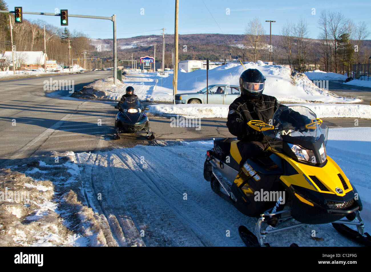 Snowmobile, snow mobile, crosses road of city street of small New ...