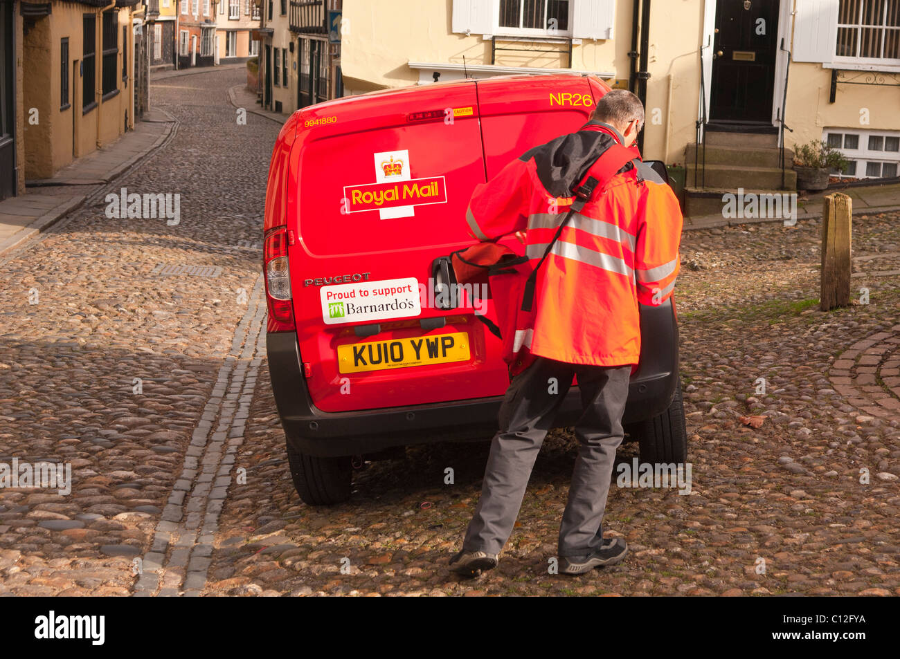 A Royal Mail postman delivering mail in Elm hill in Norwich , Norfolk ...