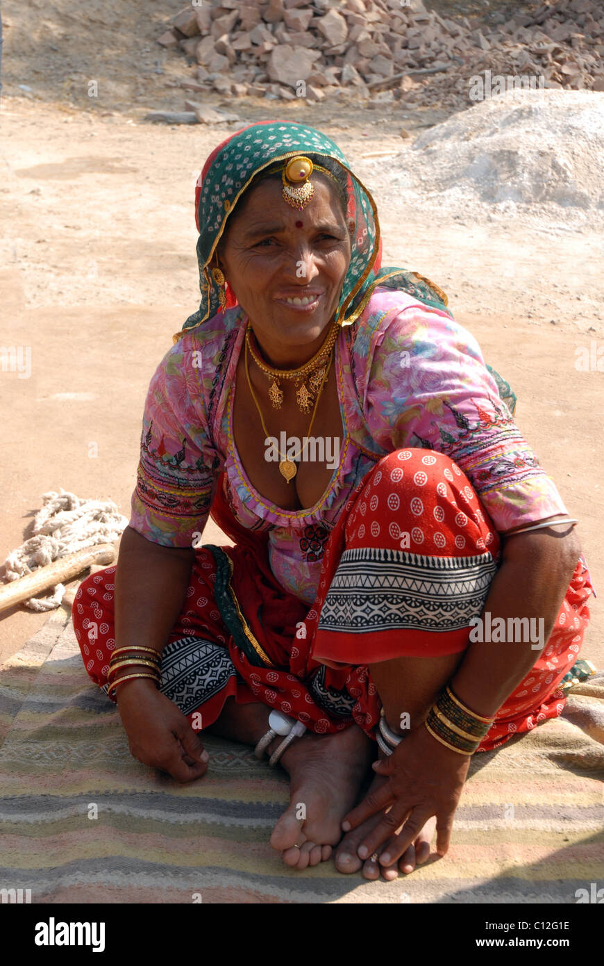 Portrait of Indian lady squatting/sitting down on blanket in Rajasthani ...