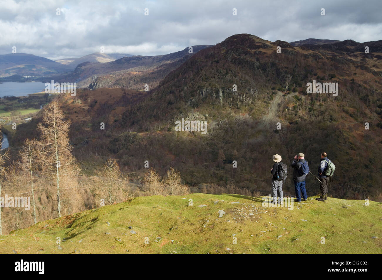 Three walkers on Castle crag looking at the view with Derwent and ...