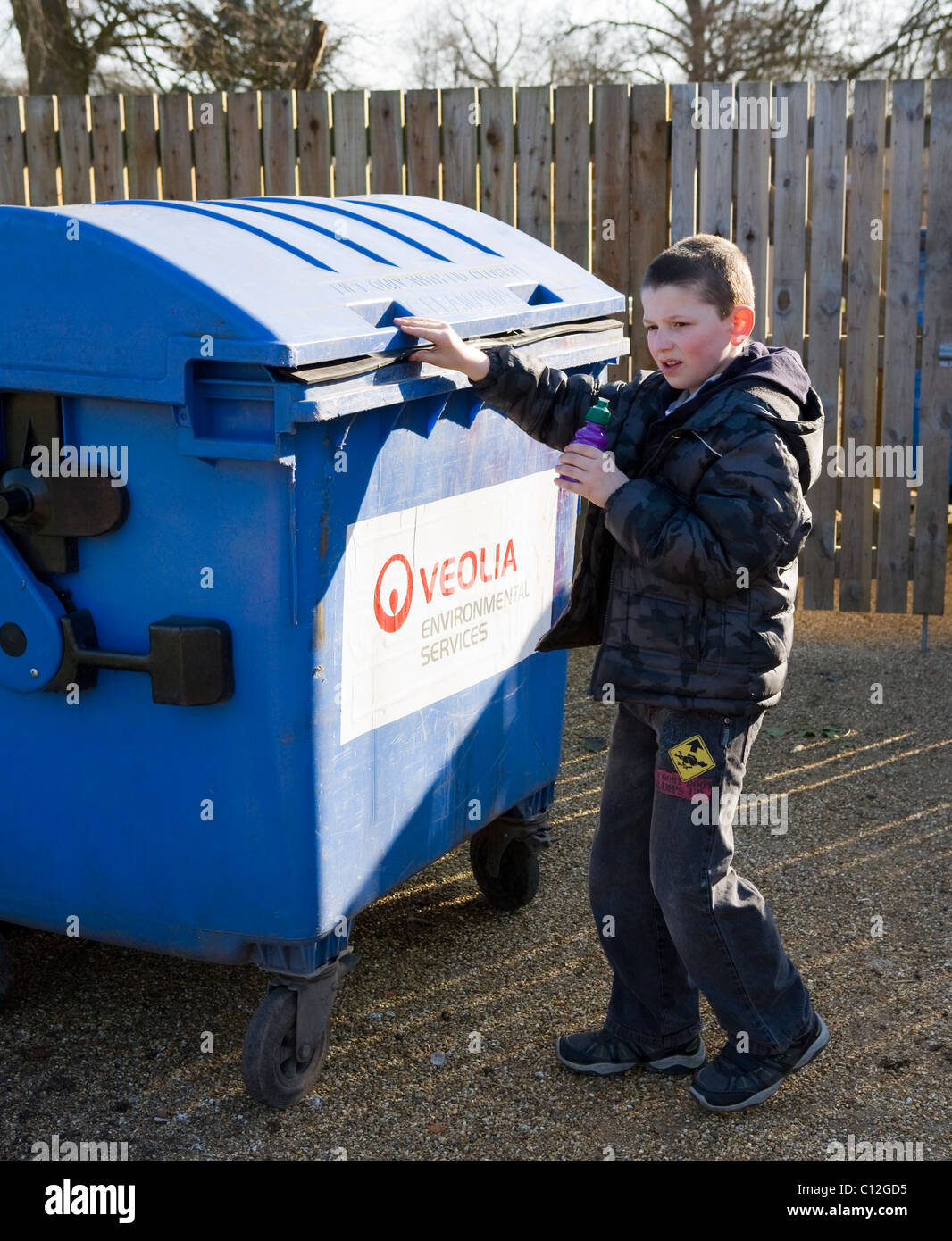 A young boy disposing of litter in waste bin Stock Photo - Alamy