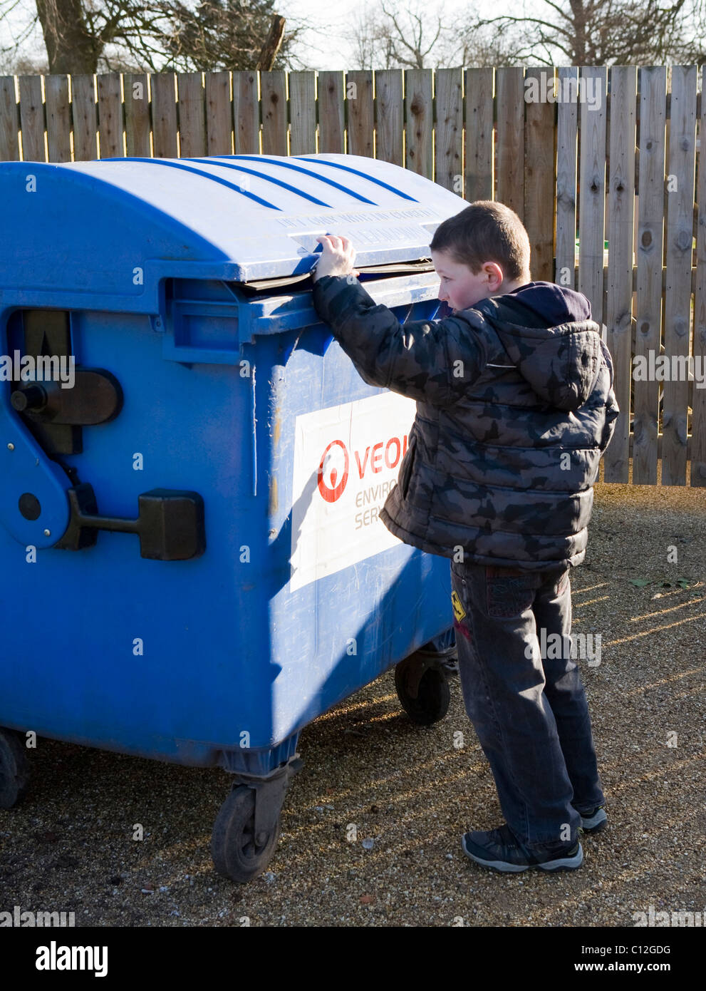 A young boy disposing of litter in waste bin Stock Photo - Alamy