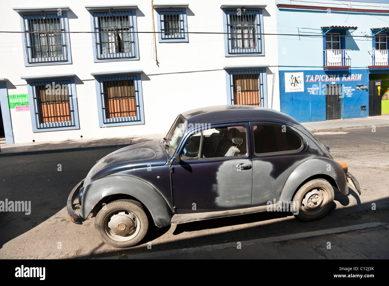 venerable Volkswagen beetle bug with patched body work parked at curb ...