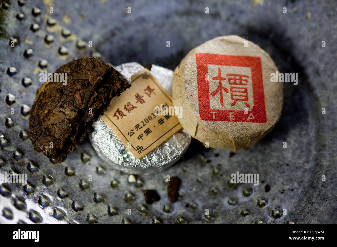 Three tablets of Chinese black tea - one unwrapped and crumbling Stock ...