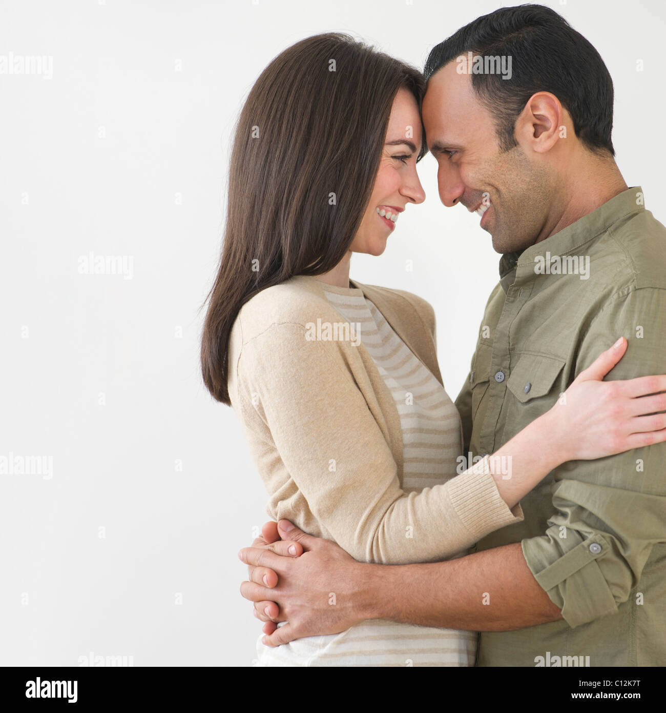 Happy couple embracing, studio shot Stock Photo - Alamy