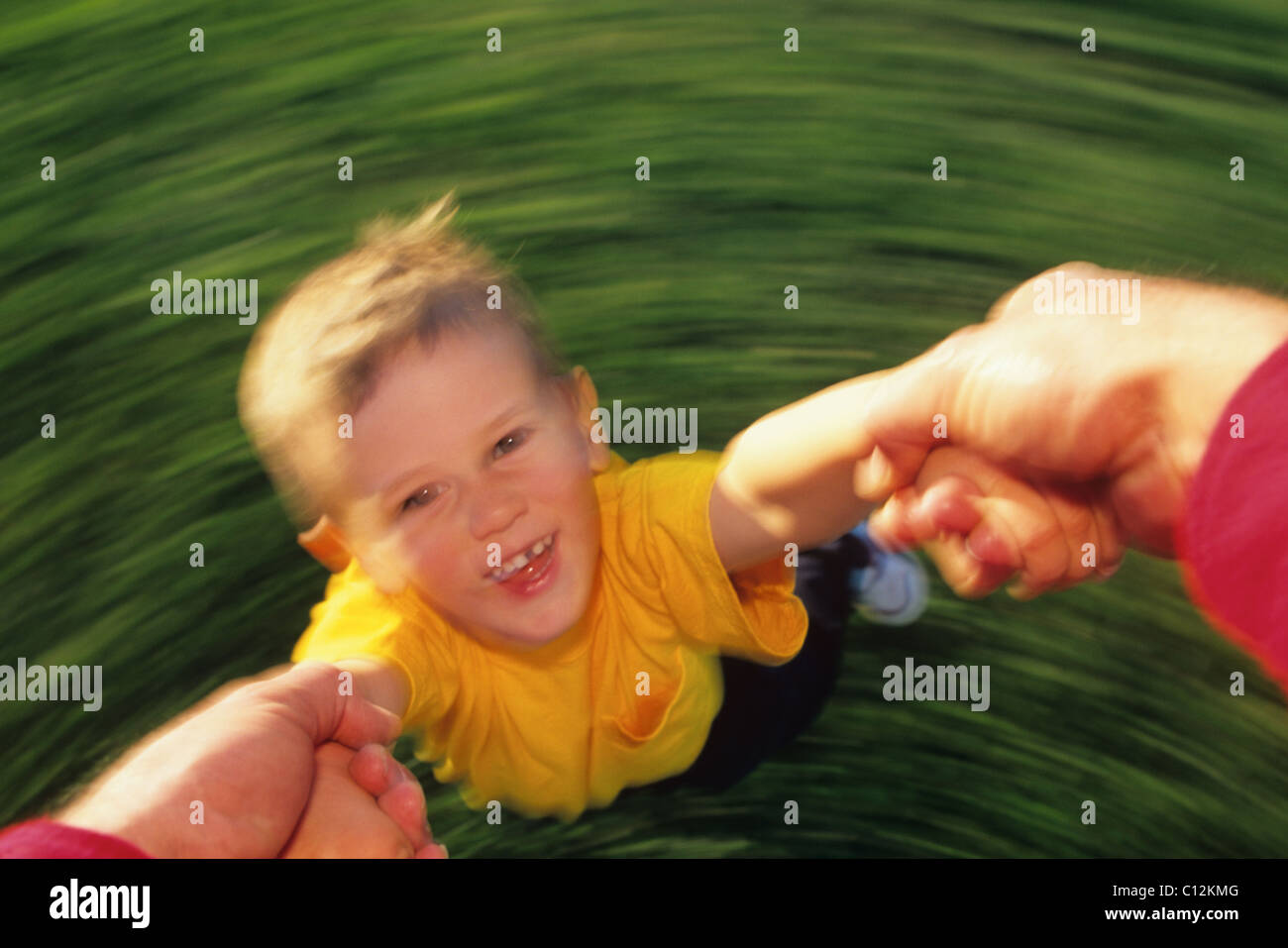 Adult spinning a child in circles Stock Photo - Alamy
