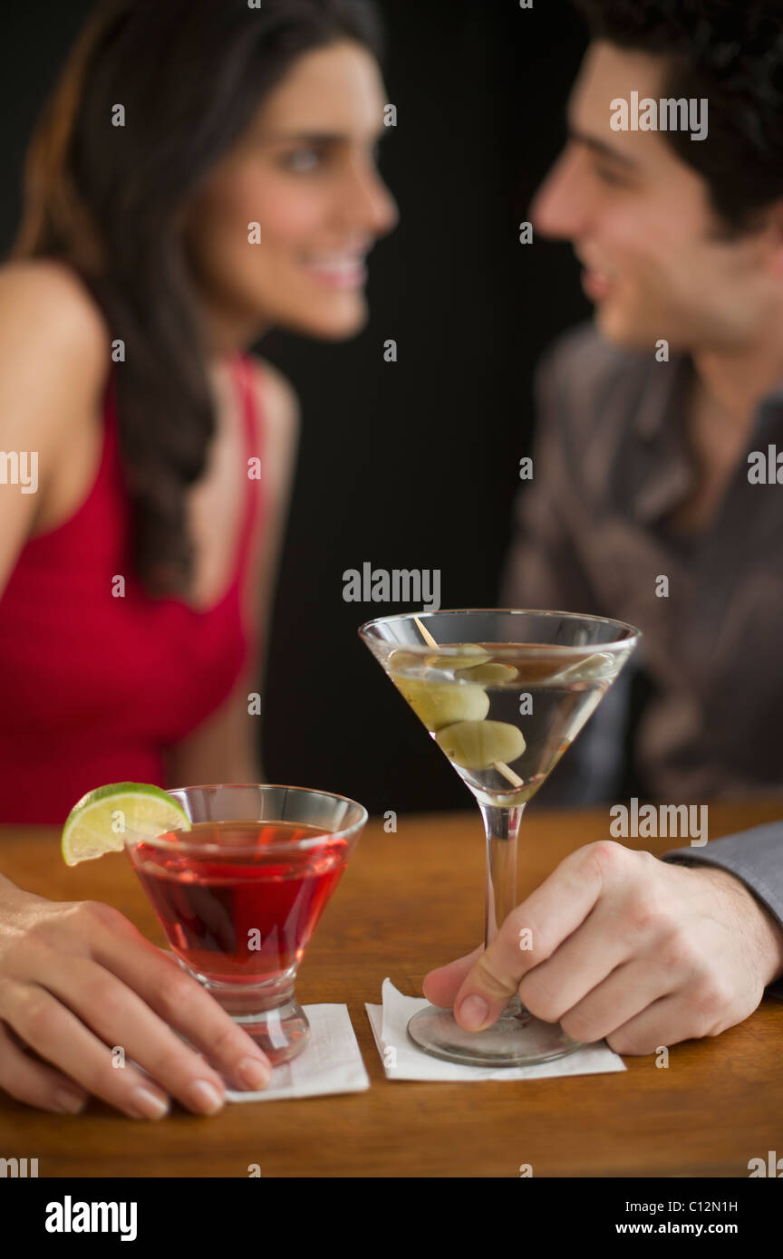 Young couple having drinks and flirting, studio shot Stock Photo - Alamy