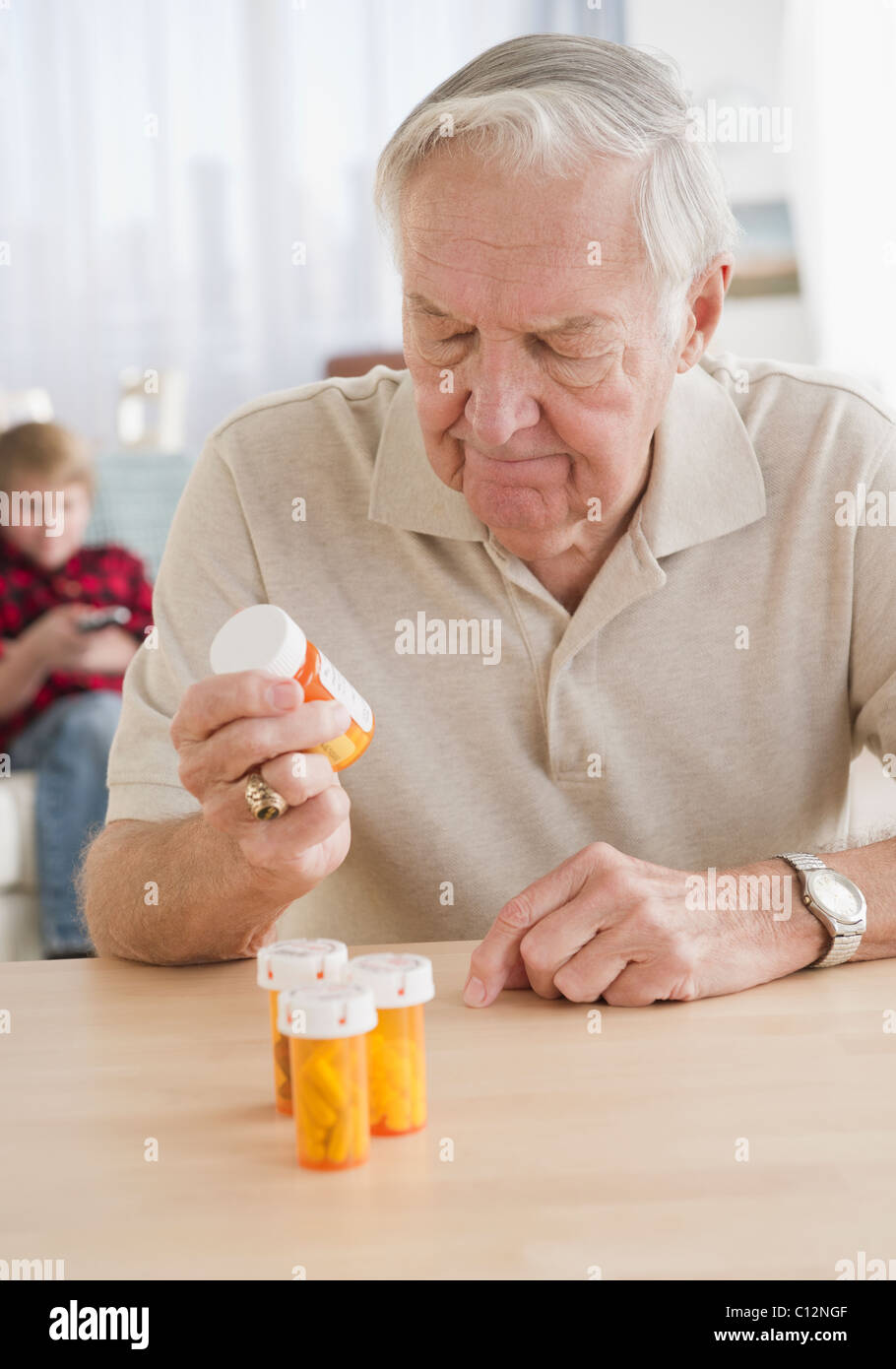 USA, New Jersey, Jersey City, grandfather holding pill bottle, grandson ...