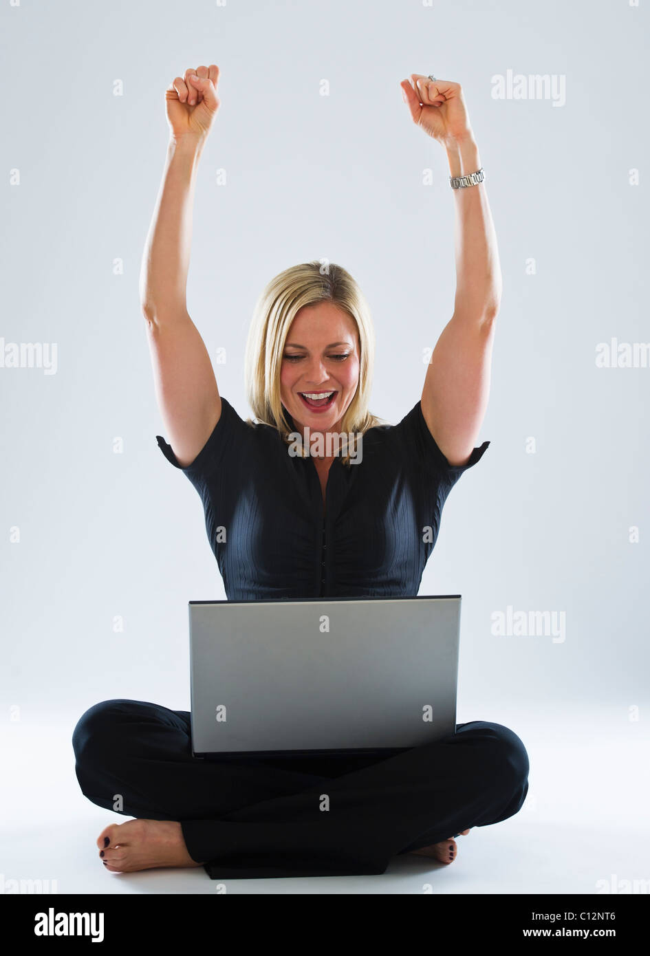 Young woman using laptop, celebrating Stock Photo - Alamy