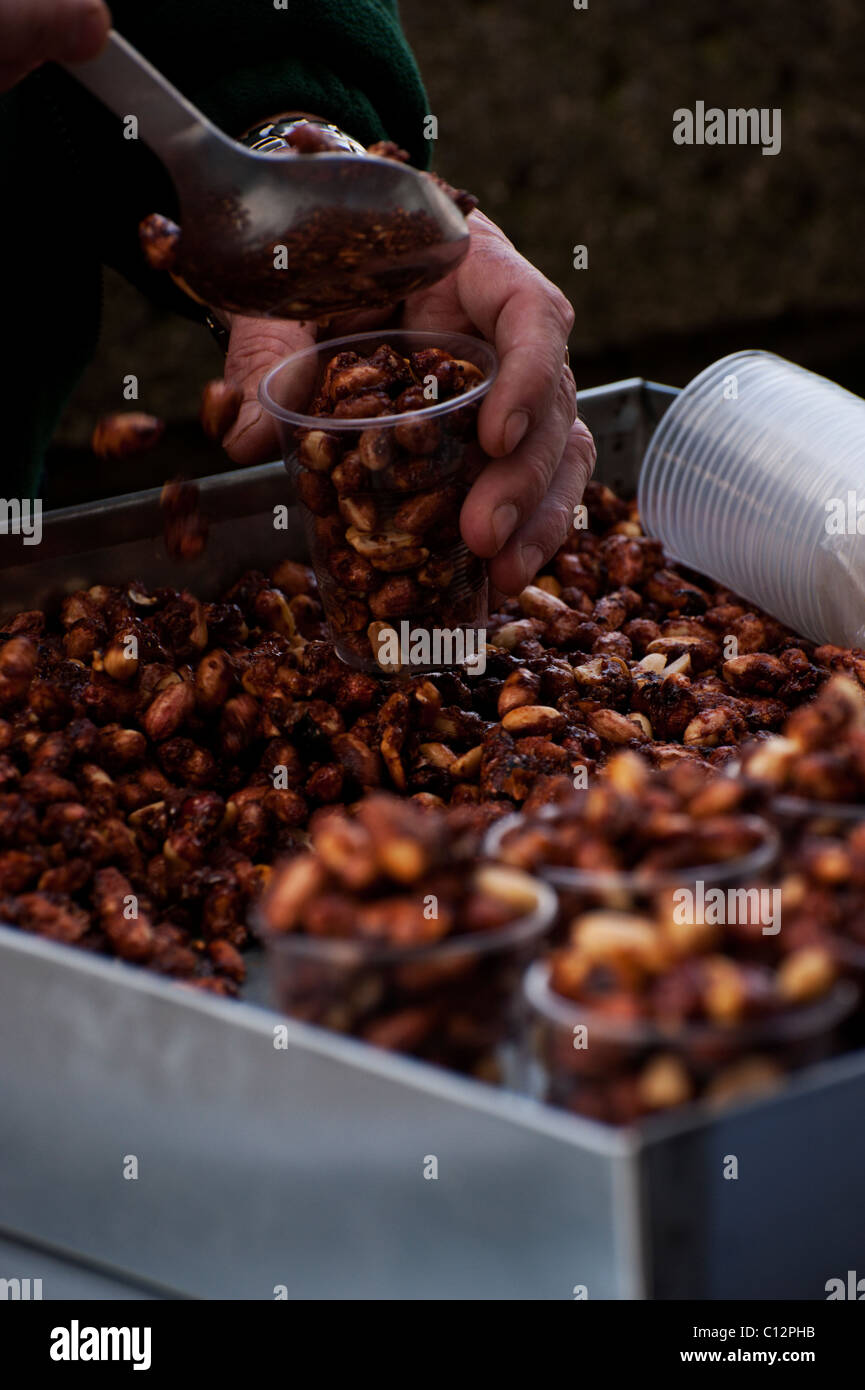 A street vendor serving hot candied peanuts Stock Photo - Alamy