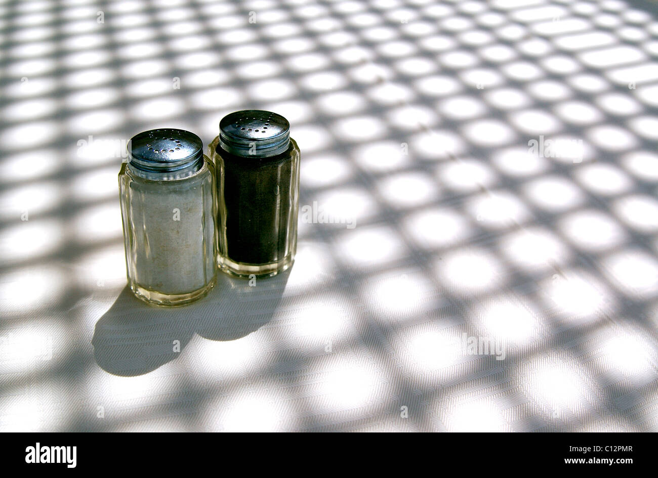 Glass salt and cellar pots on sunlit table Stock Photo - Alamy