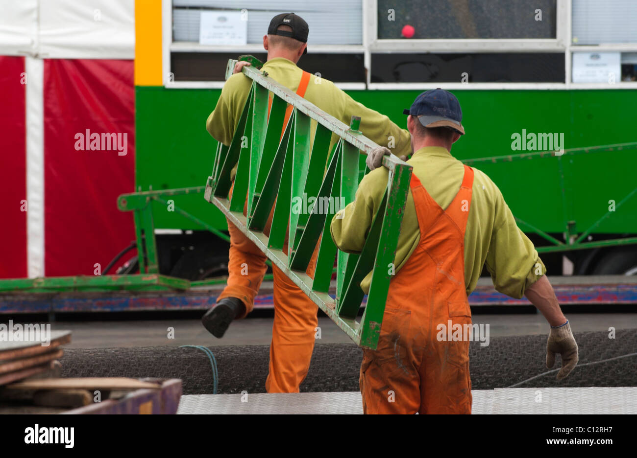 Two men carrying a beam Stock Photo - Alamy