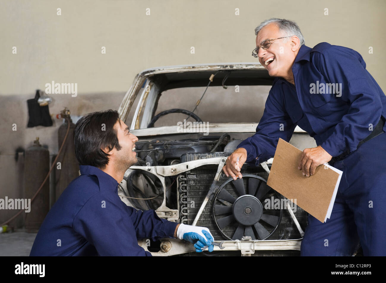 Auto mechanic with an apprentice in a garage Stock Photo - Alamy