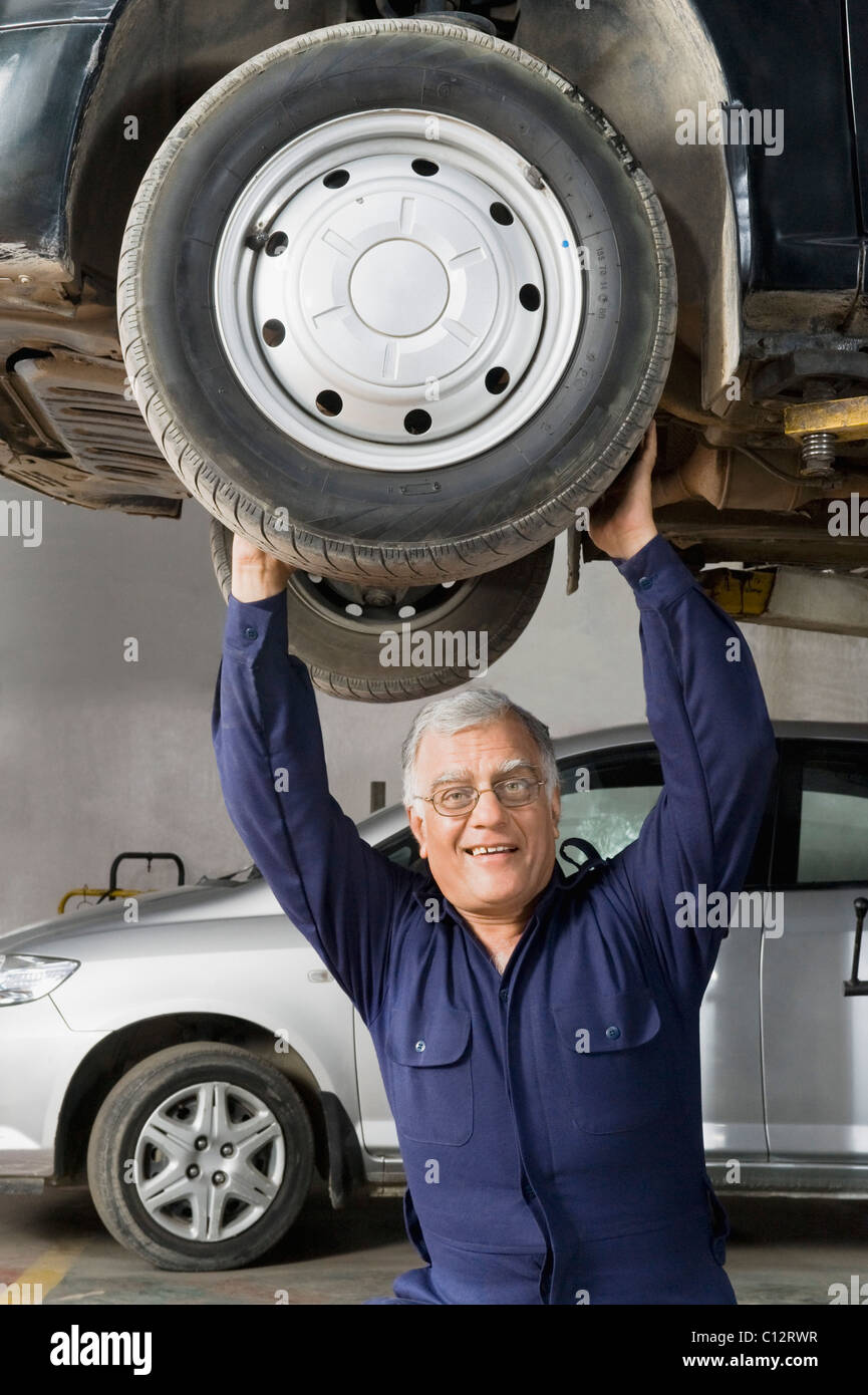 Auto mechanic working on a car wheel in a garage Stock Photo - Alamy
