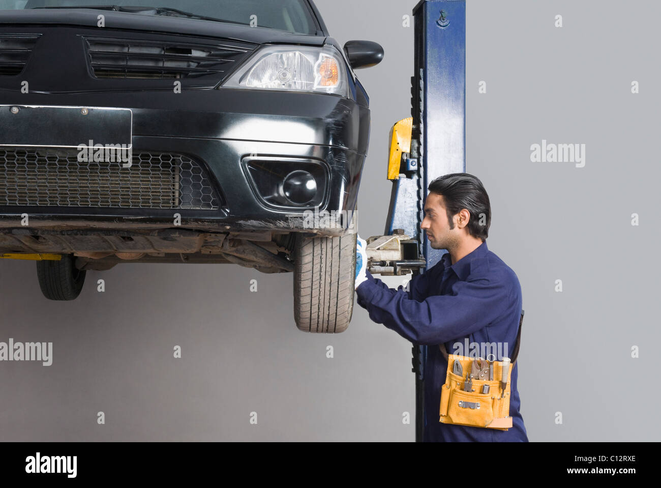 Auto mechanic working on a car wheel in a garage Stock Photo - Alamy