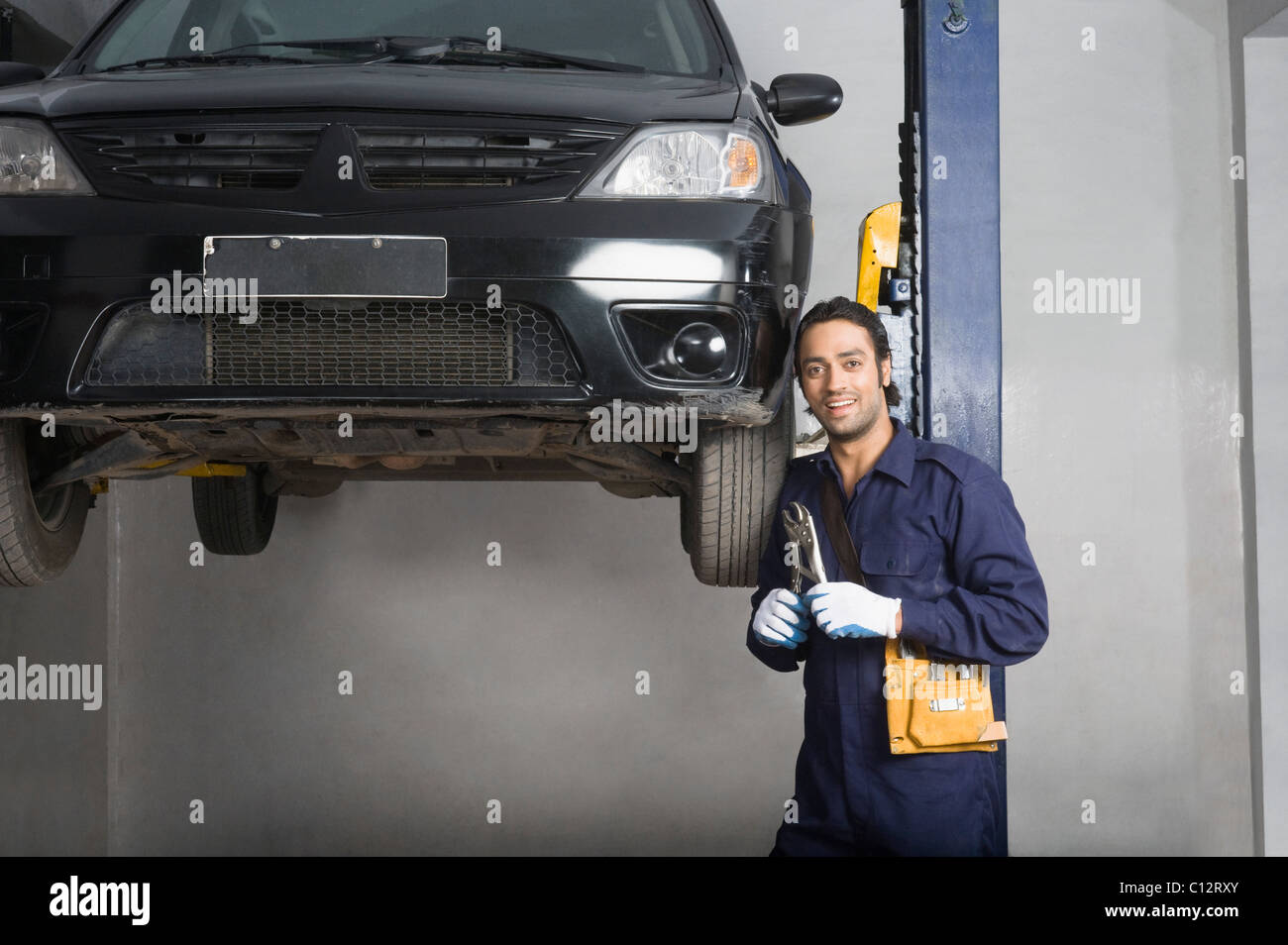 Auto mechanic working on a car wheel in a garage Stock Photo - Alamy