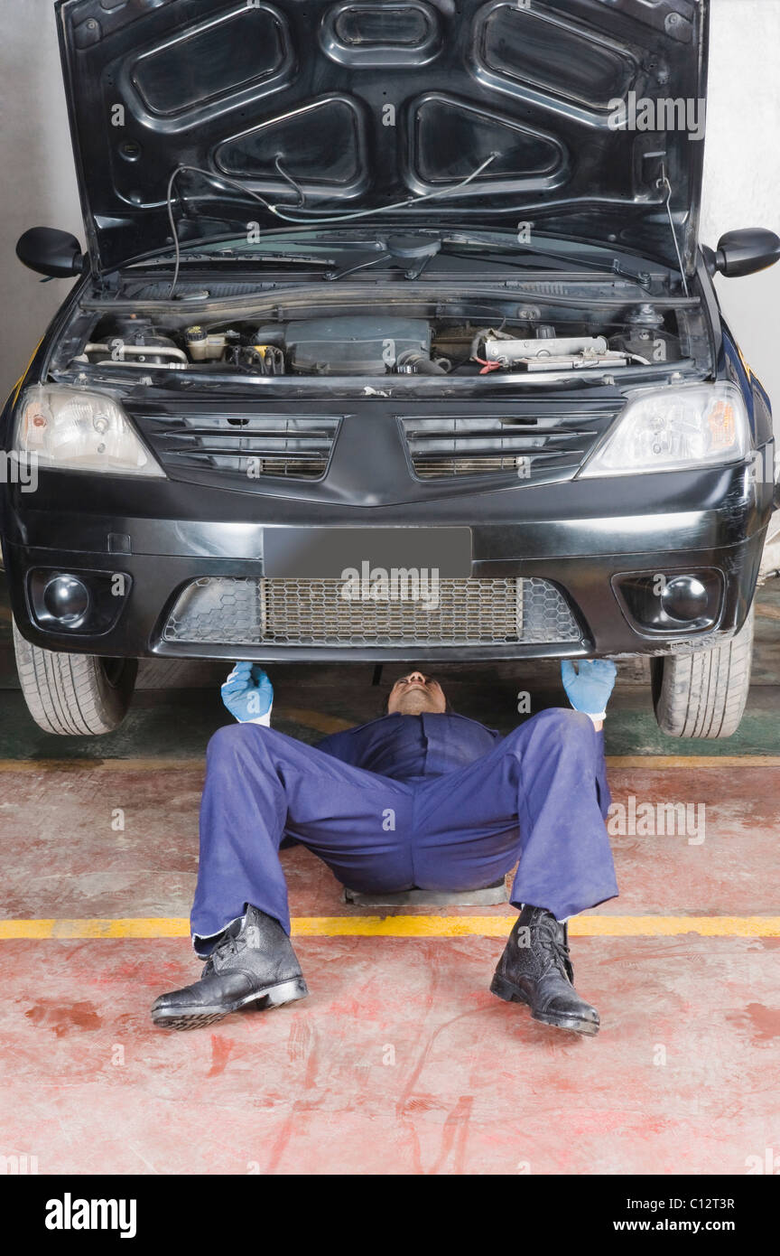 Auto mechanic repairing a car in a garage Stock Photo - Alamy