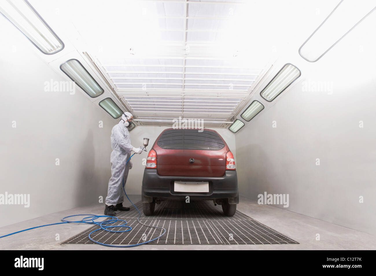 Auto mechanic painting a car in a garage Stock Photo - Alamy