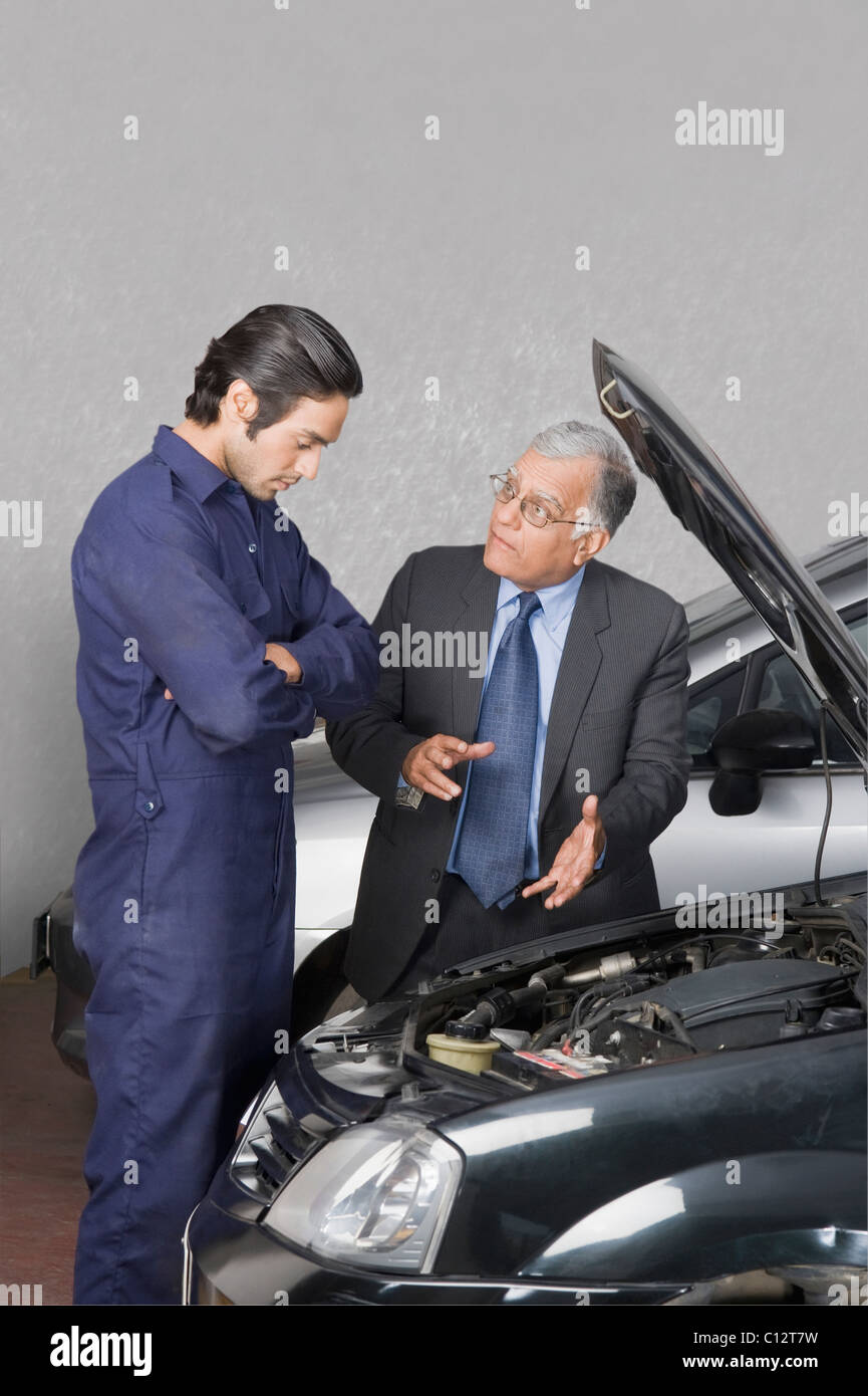Customer explaining car problems to the auto mechanic Stock Photo - Alamy