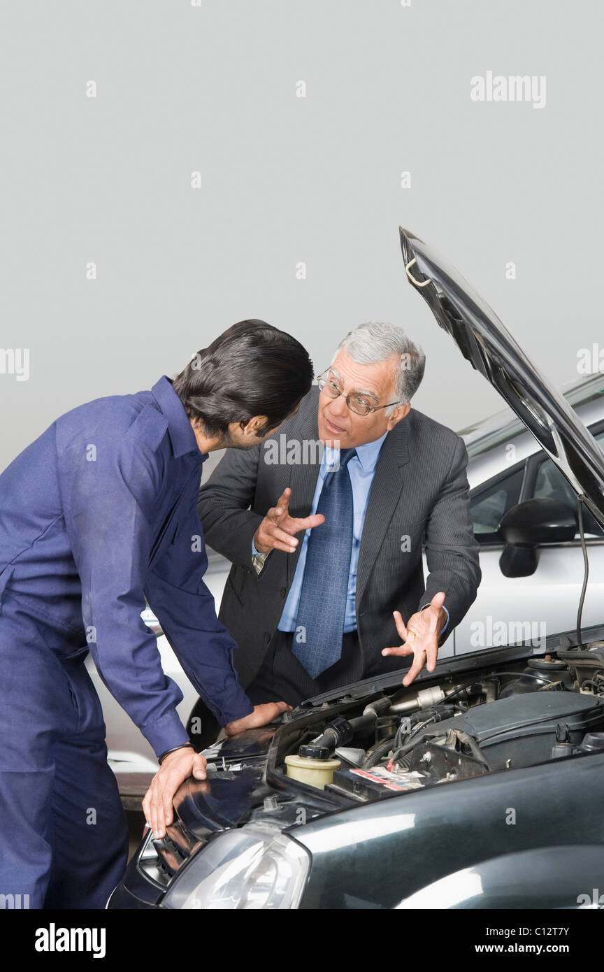 Customer explaining car problems to the auto mechanic Stock Photo - Alamy