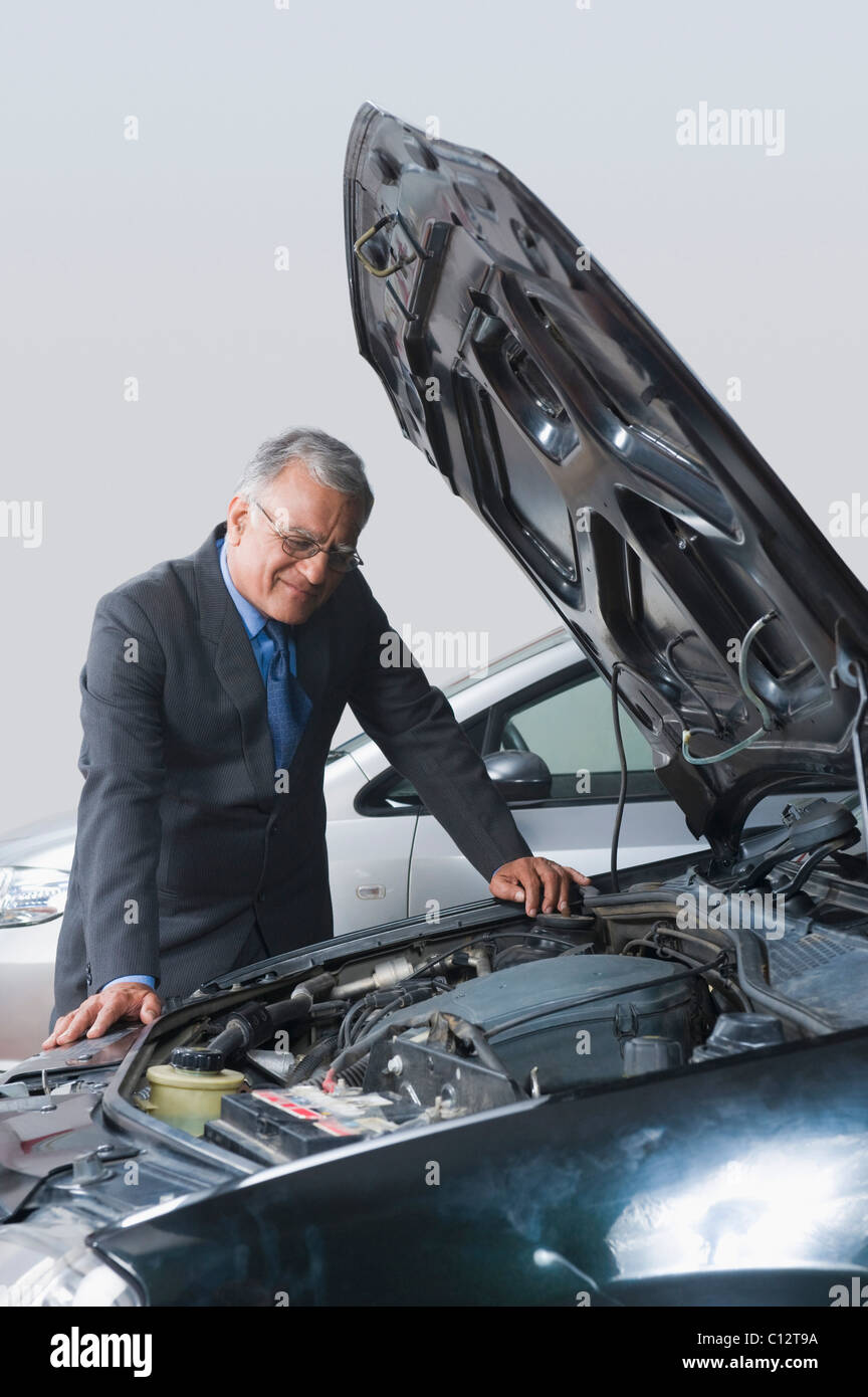 Businessman examining a car Stock Photo - Alamy