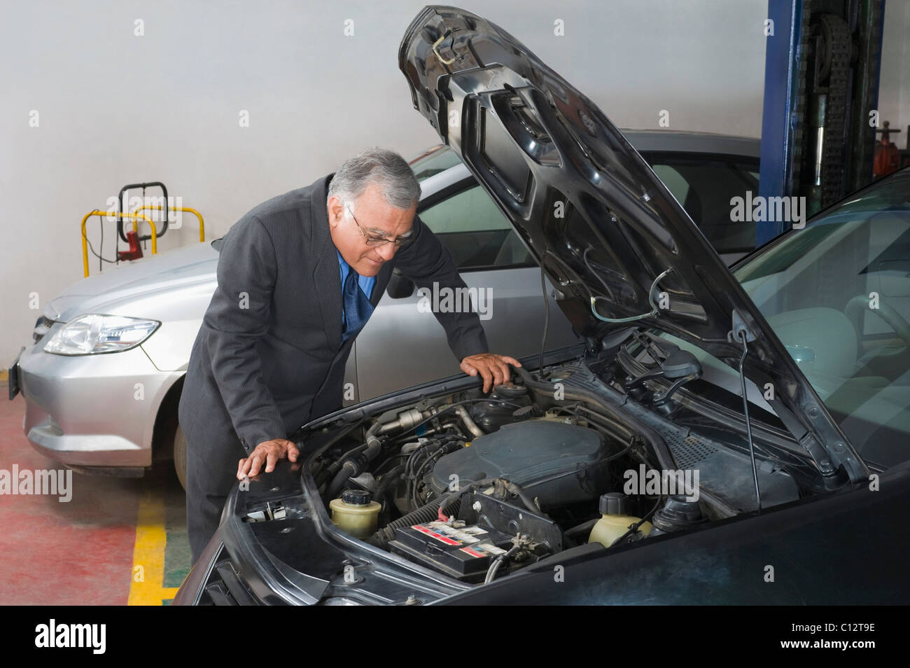 Businessman examining a car Stock Photo - Alamy