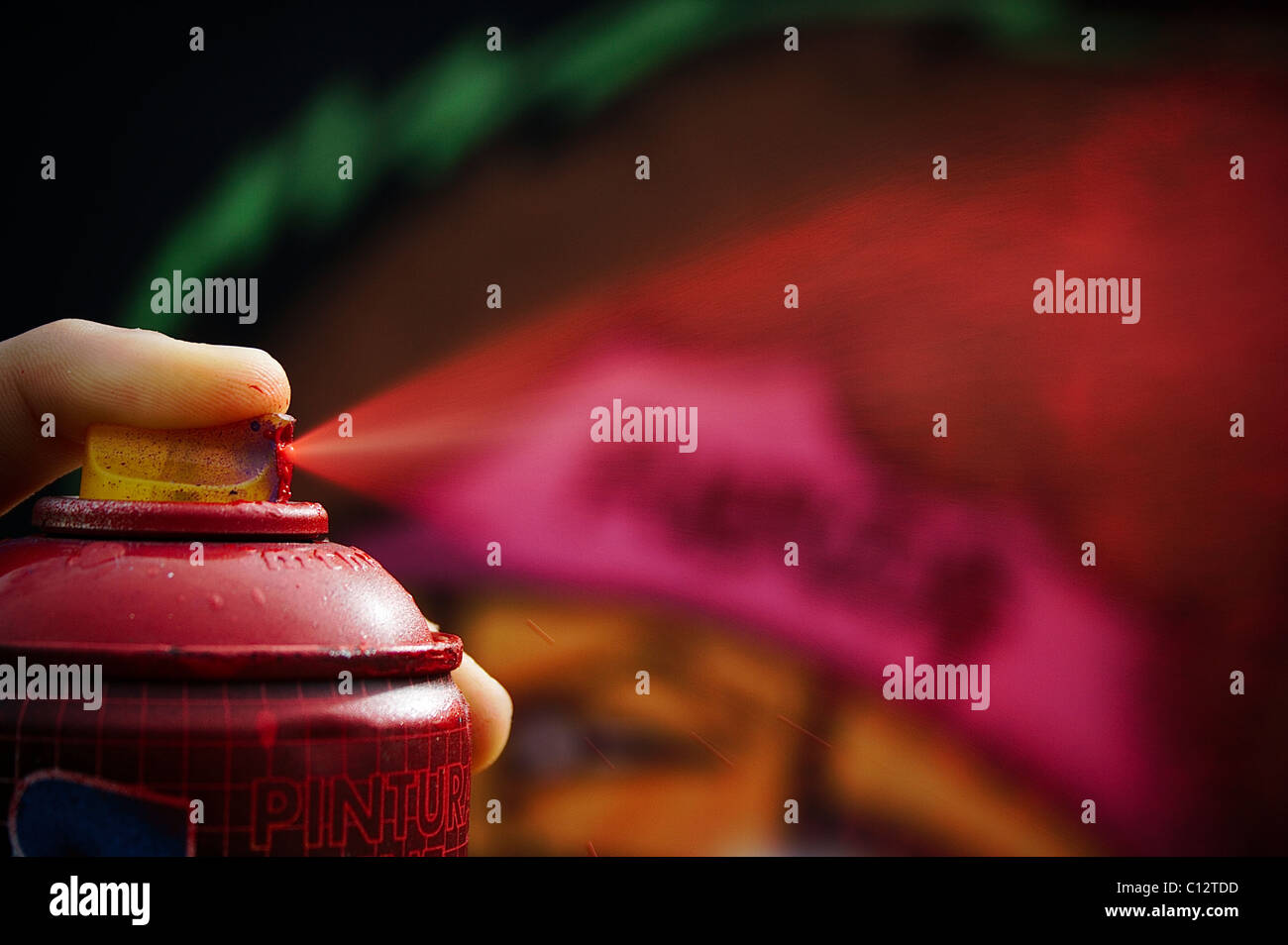 Young man pressing red aerosol can Stock Photo - Alamy