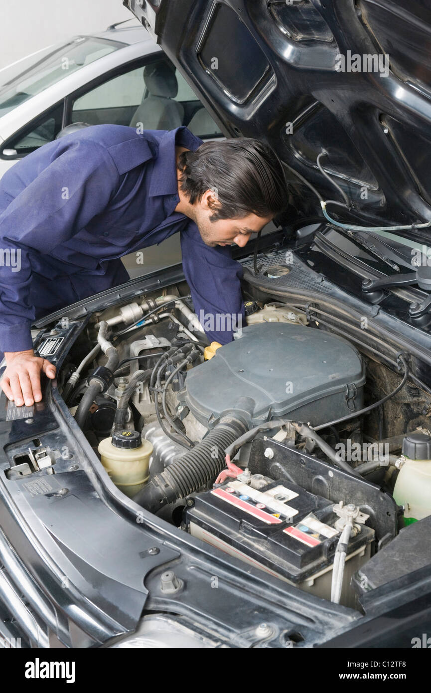Auto mechanic repairing a car in a garage Stock Photo - Alamy