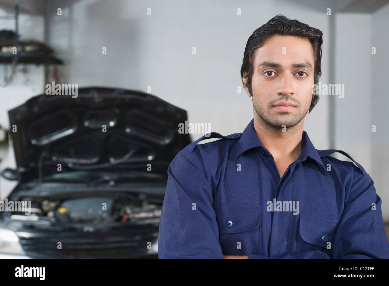 Portrait of an auto mechanic with a car in the background Stock Photo ...