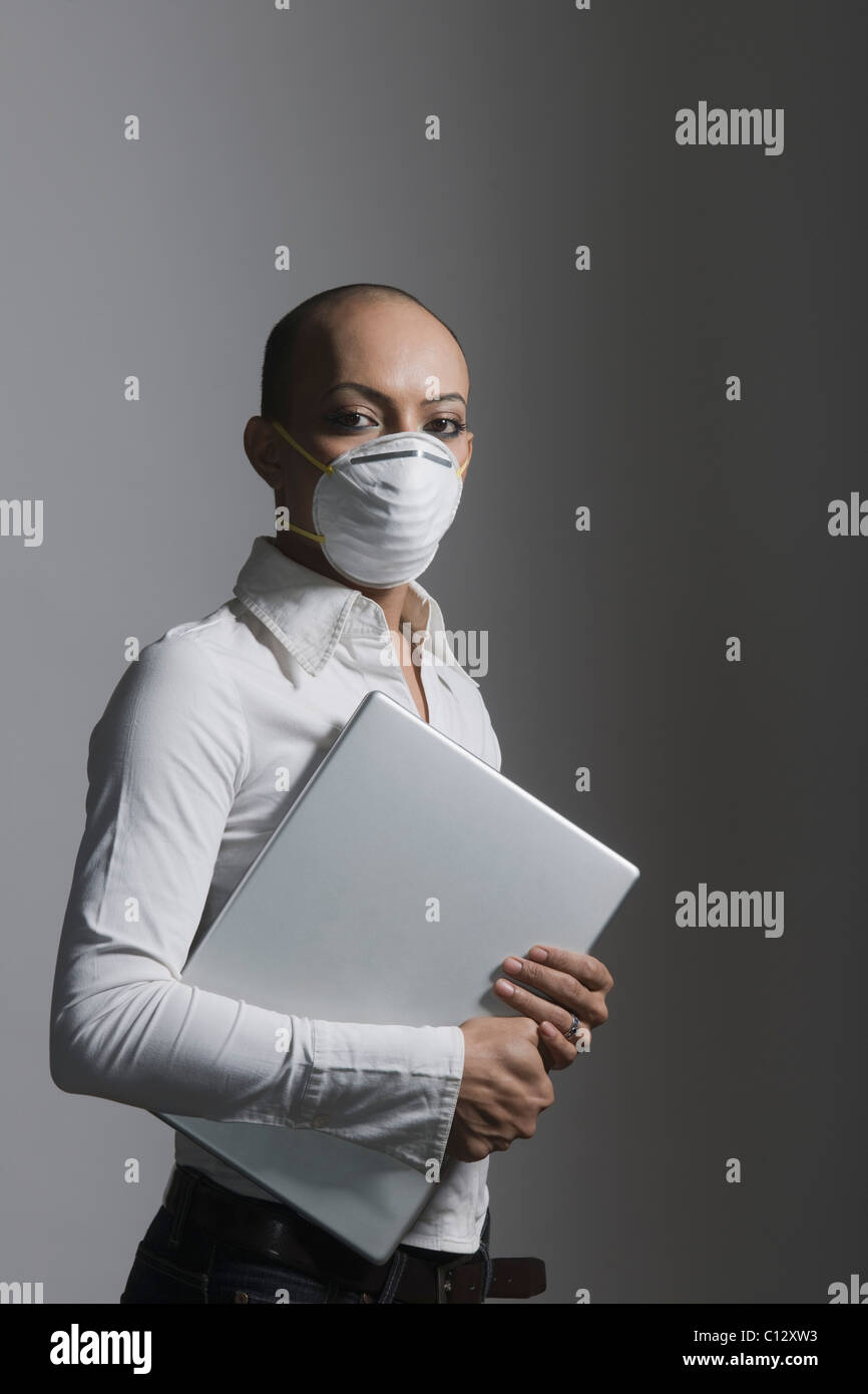 Gay man holding a laptop and wearing a flu mask Stock Photo - Alamy
