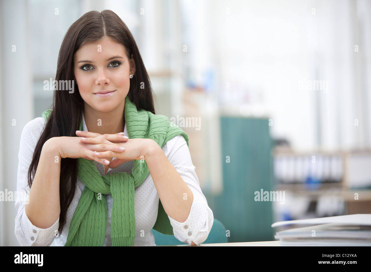 portrait of young woman sitting at desk Stock Photo - Alamy
