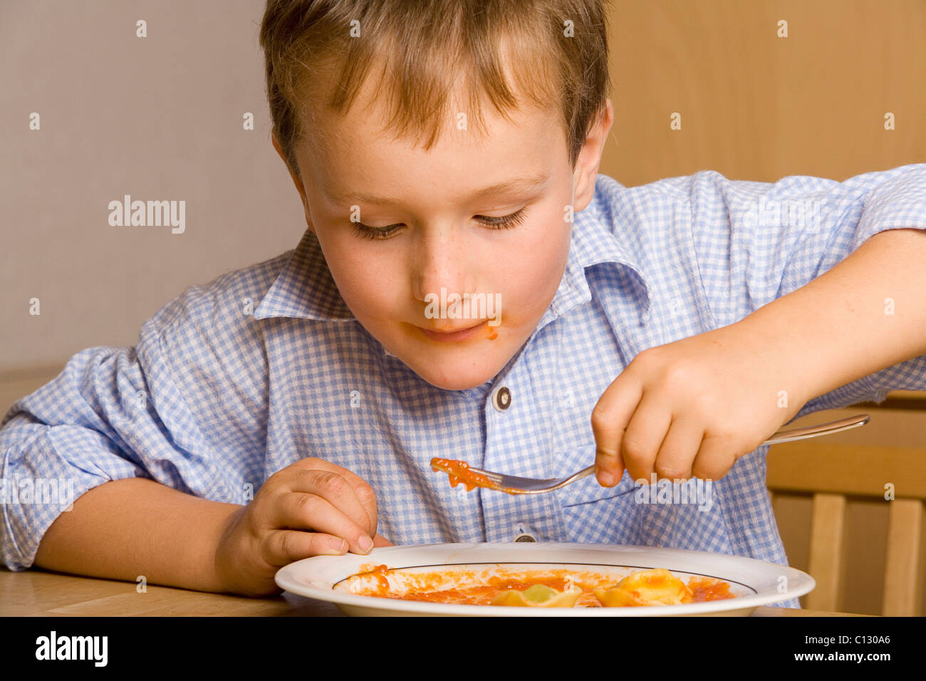 portrait of young boy eating pasta Stock Photo - Alamy