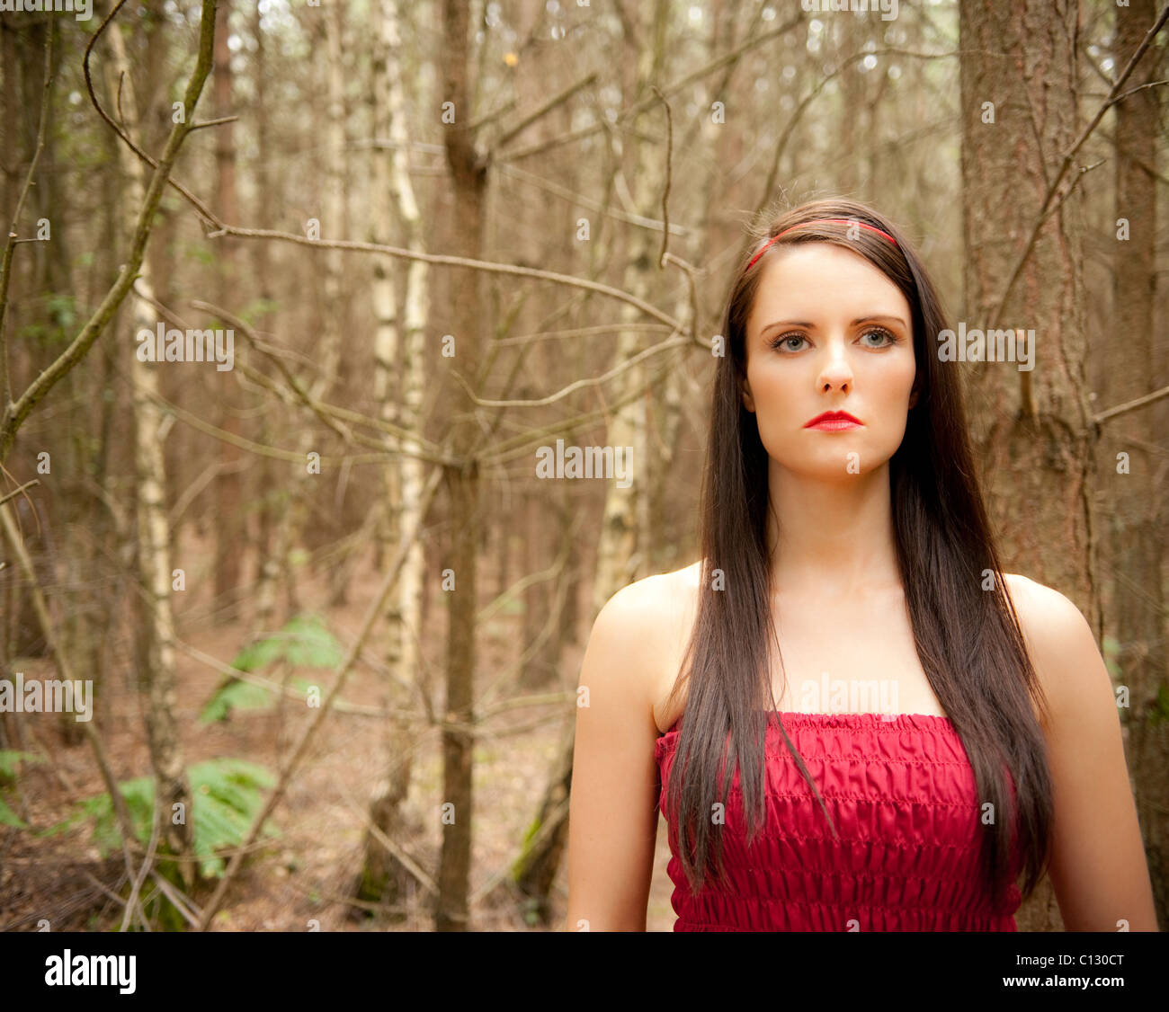 young woman in red dress in a forest Stock Photo - Alamy