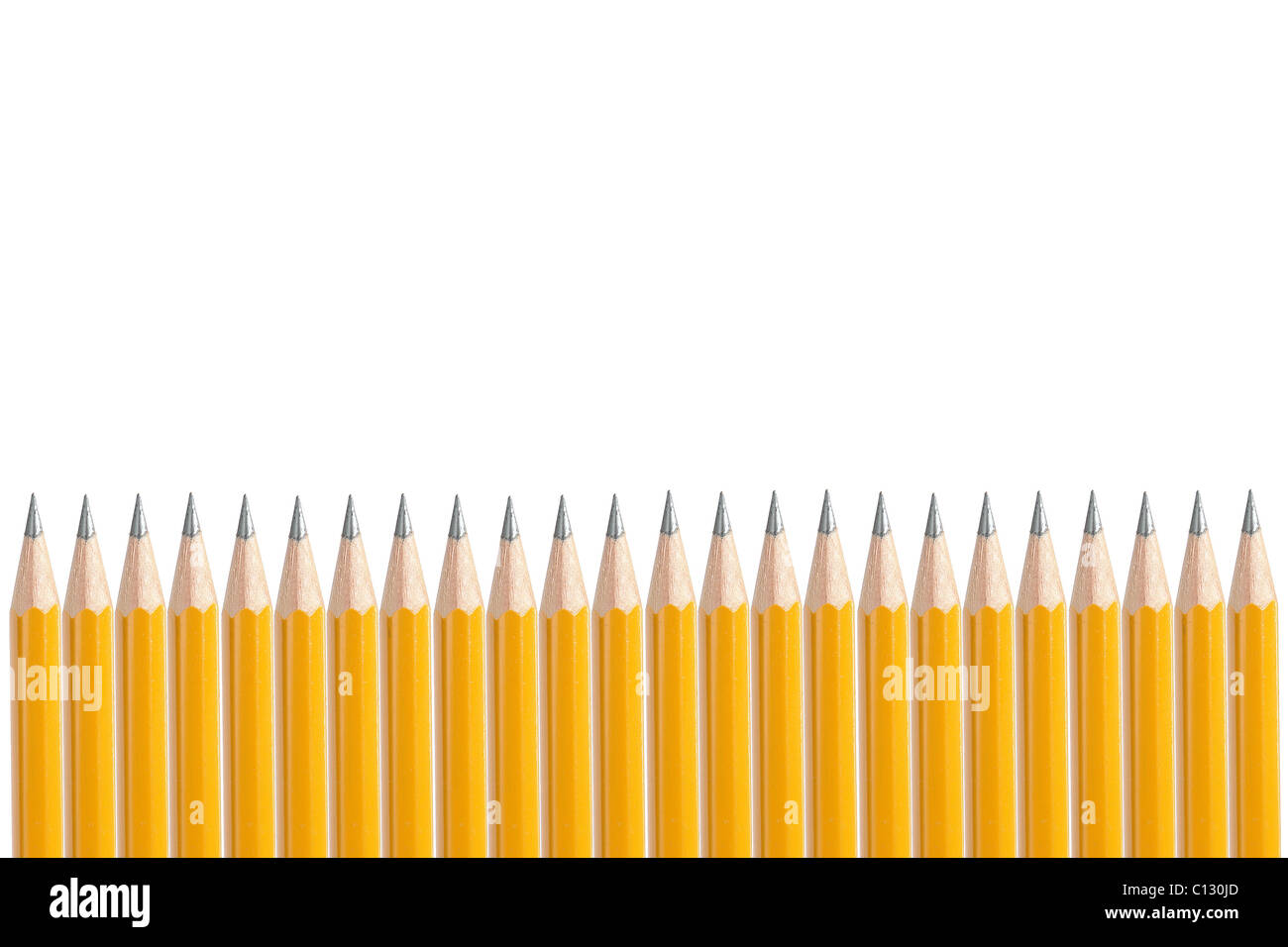Row of yellow wooden pencils with sharpened tips over white background ...
