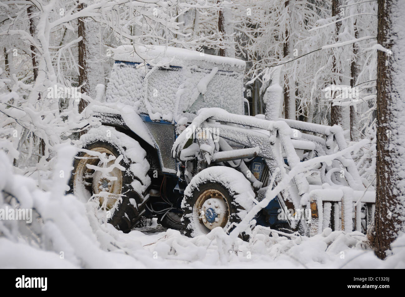 Snow covered tractor in woodland Stock Photo - Alamy