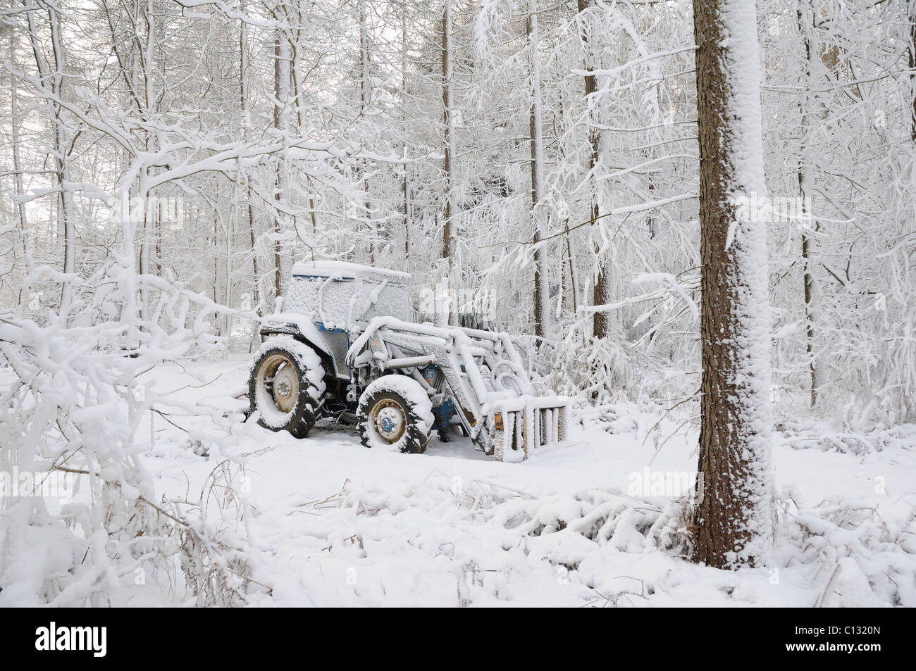 Snow covered tractor in woodland Stock Photo - Alamy