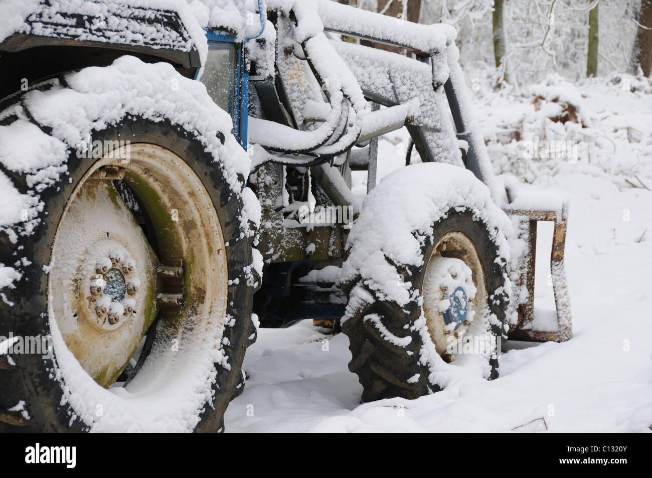 Snow covered tractor in woodland Stock Photo - Alamy