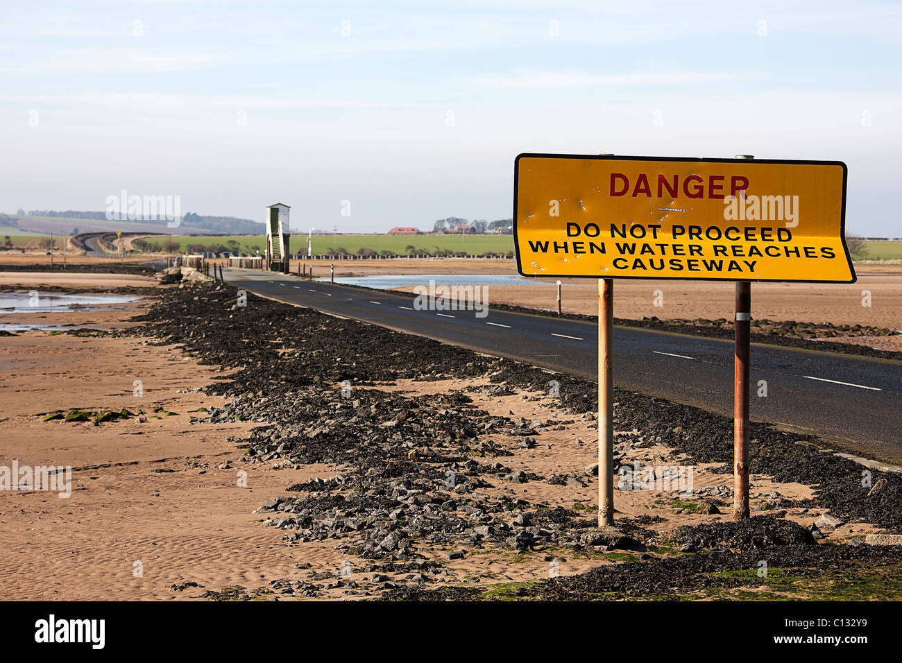 Danger sign 0n causeway with refuge post behind. Holy island Stock ...